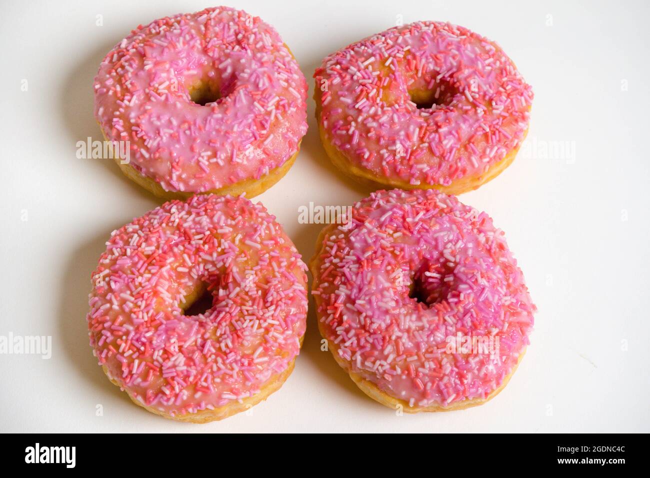 Four Iced Ring Donuts On A White Background Stock Photo - Alamy