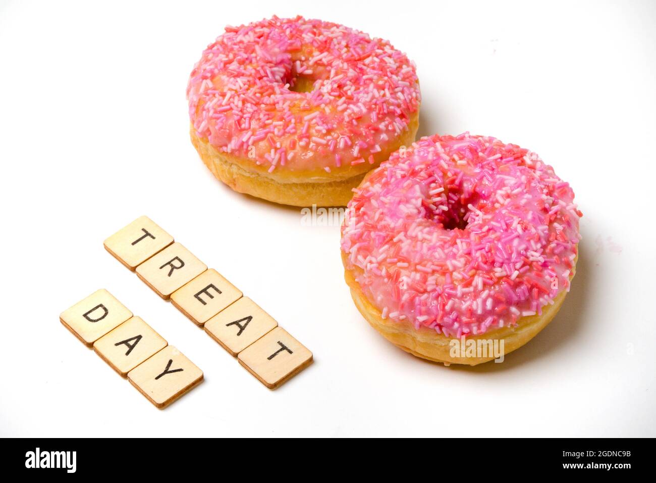 Two Iced Ring Donuts On A White Background With A Sign Reading Treat ...