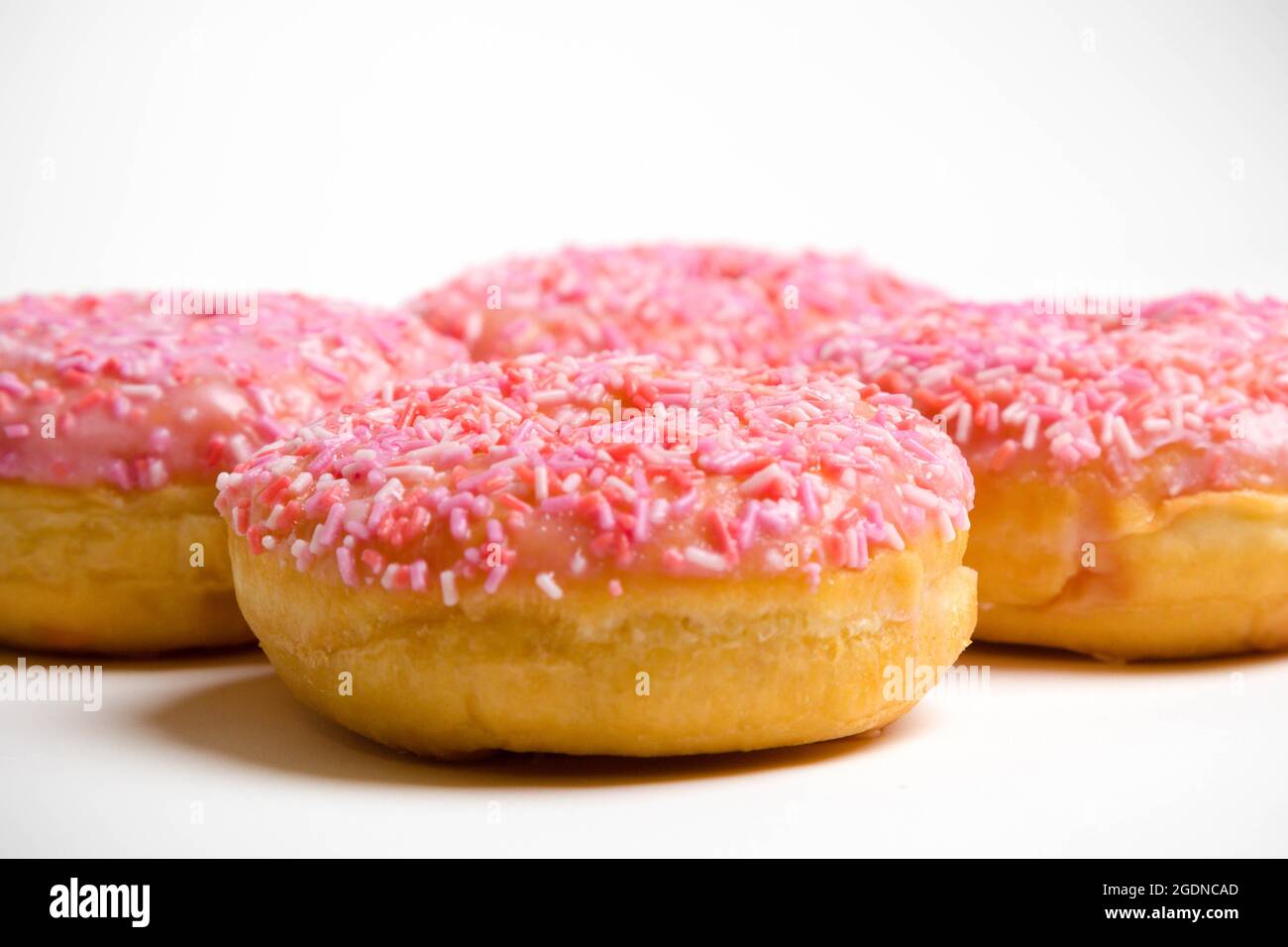Four Iced Ring Donuts On A White Background Stock Photo - Alamy