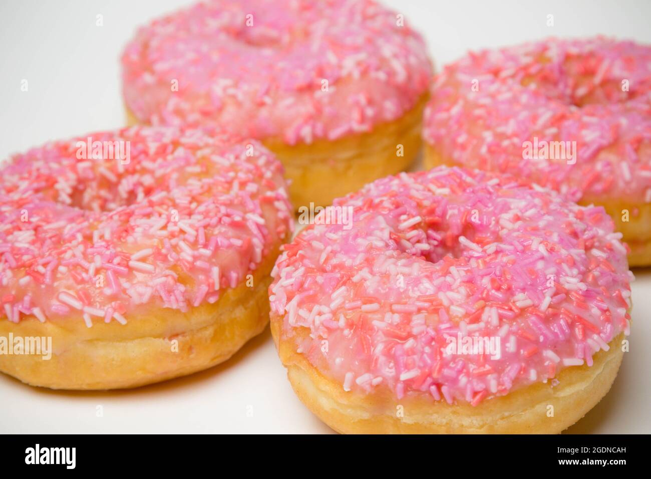 Four Iced Ring Donuts On A White Background Stock Photo - Alamy