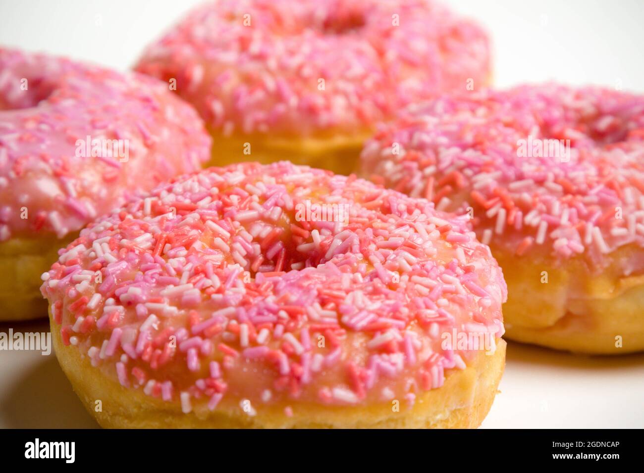 Four Iced Ring Donuts On A White Background Stock Photo - Alamy