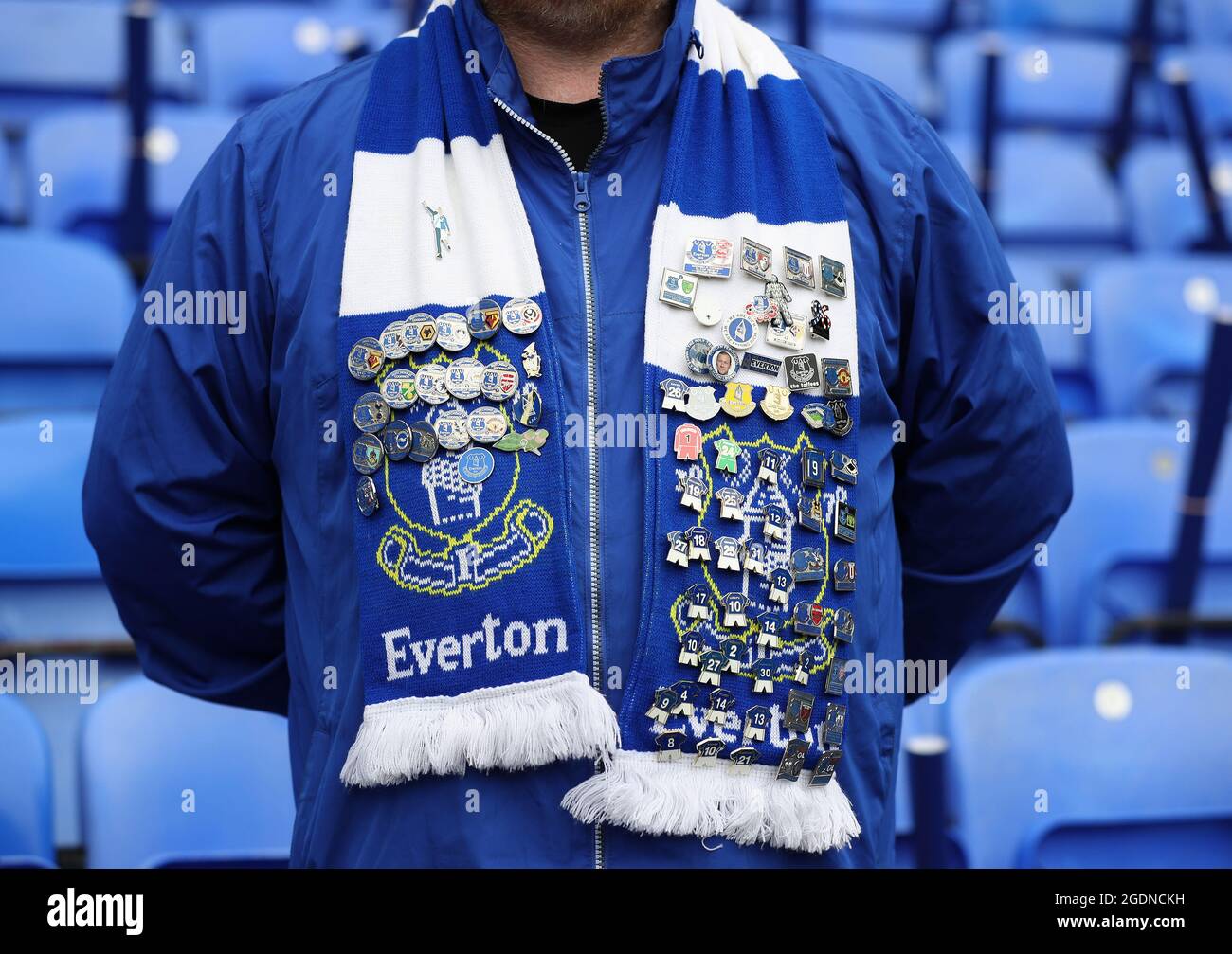 An Everton fan wearing a scarf adorned with pin badges before the ...