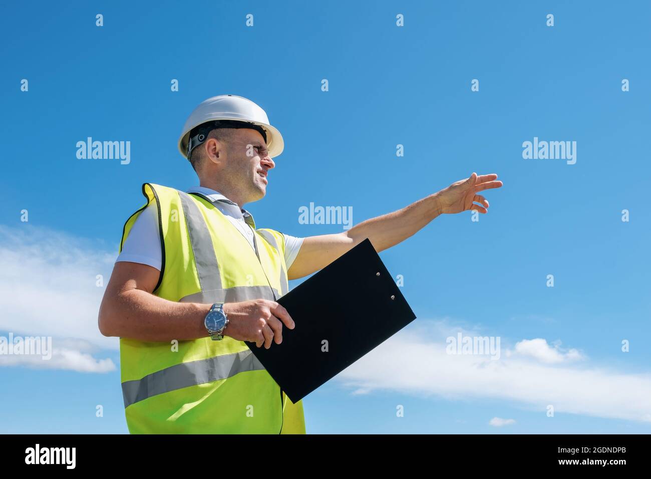 Male contractor pointing away during work Stock Photo - Alamy