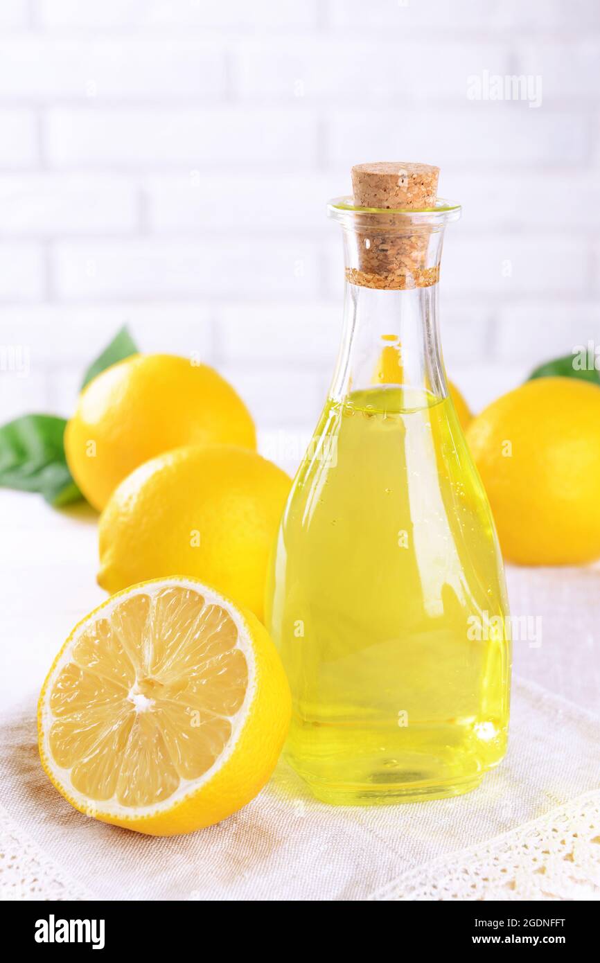 Lemon oil on table on light background Stock Photo - Alamy