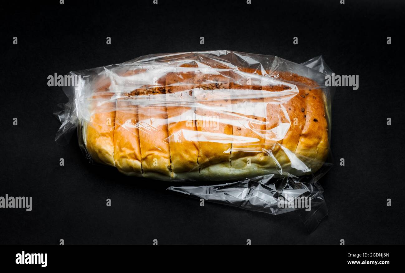 Delicious wheat bread inside of a polybag on dark texture background ...