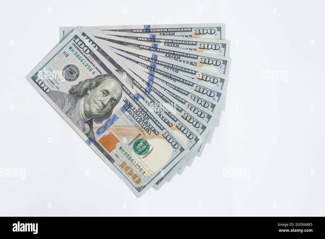 Stack of hundred dollar bills spread out on white background, isolate ...