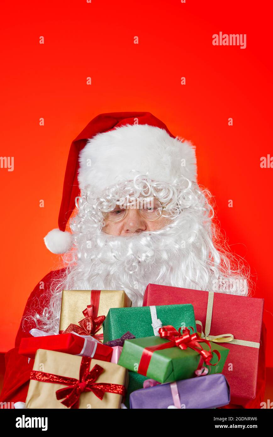 Happy Santa Claus with gift boxes in hands on red background with copy ...