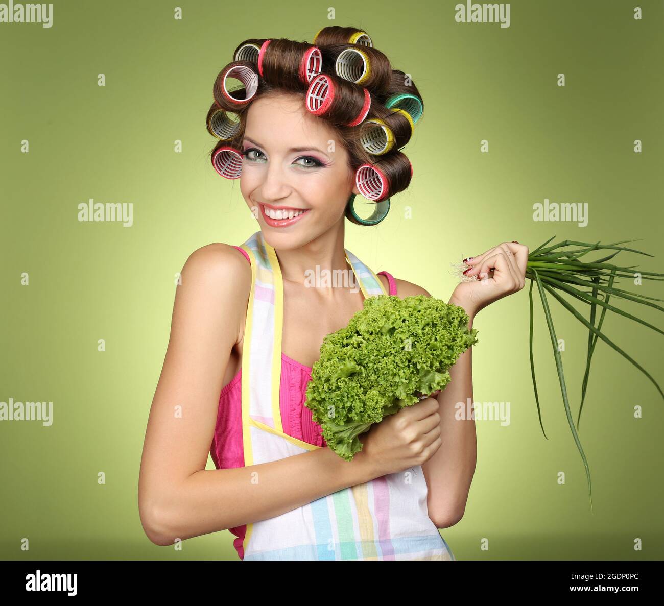 Beautiful girl in hair curlers on green background Stock Photo - Alamy