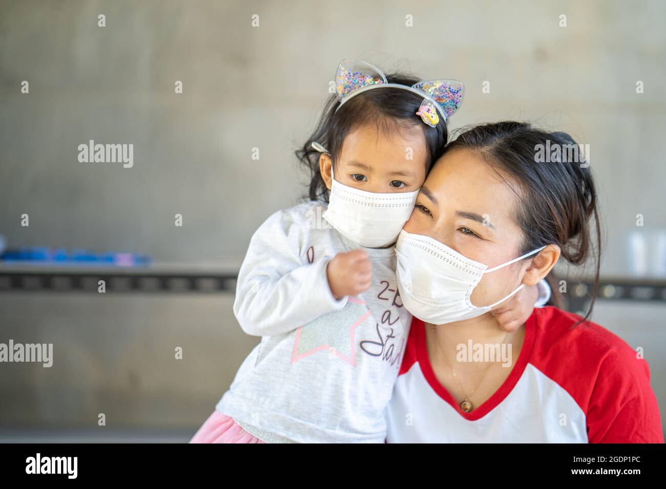 Shot Of A Cute Little Asian Girl Hugging Her Smiling Mothers Neck