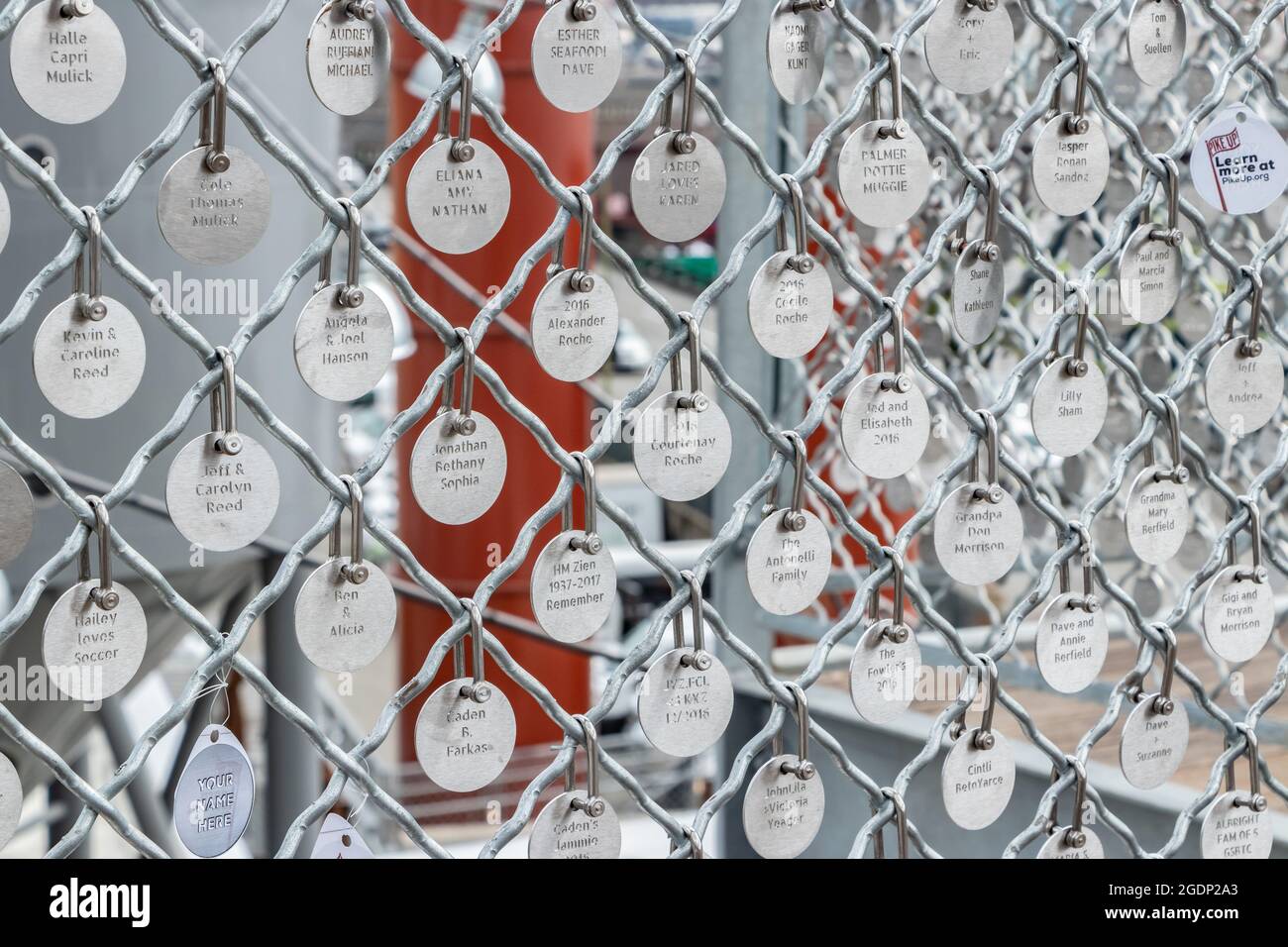 engraved metal dog tags with messages attached to wire hurricane fence ...
