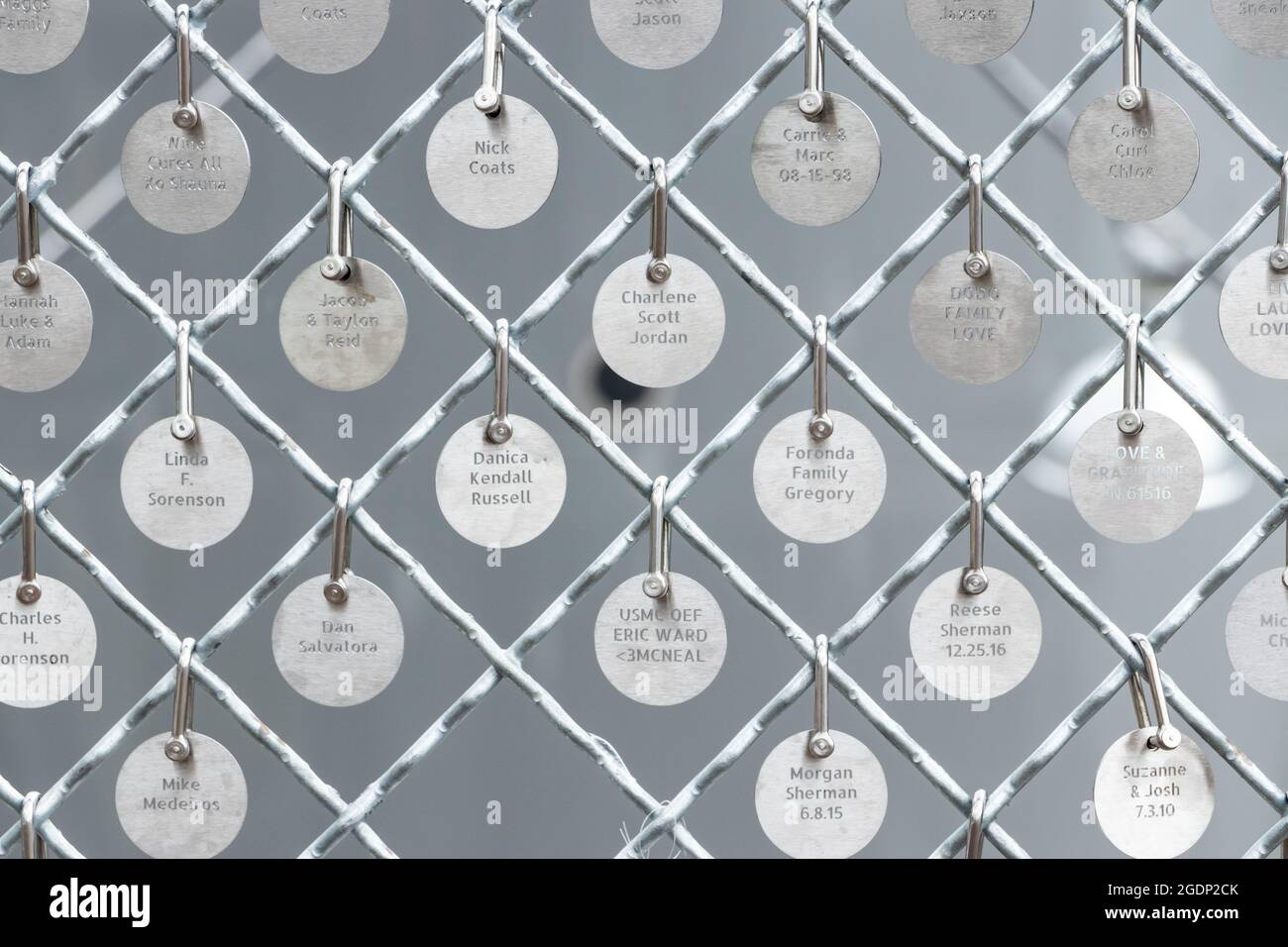engraved metal dog tags with messages attached to wire hurricane fence ...