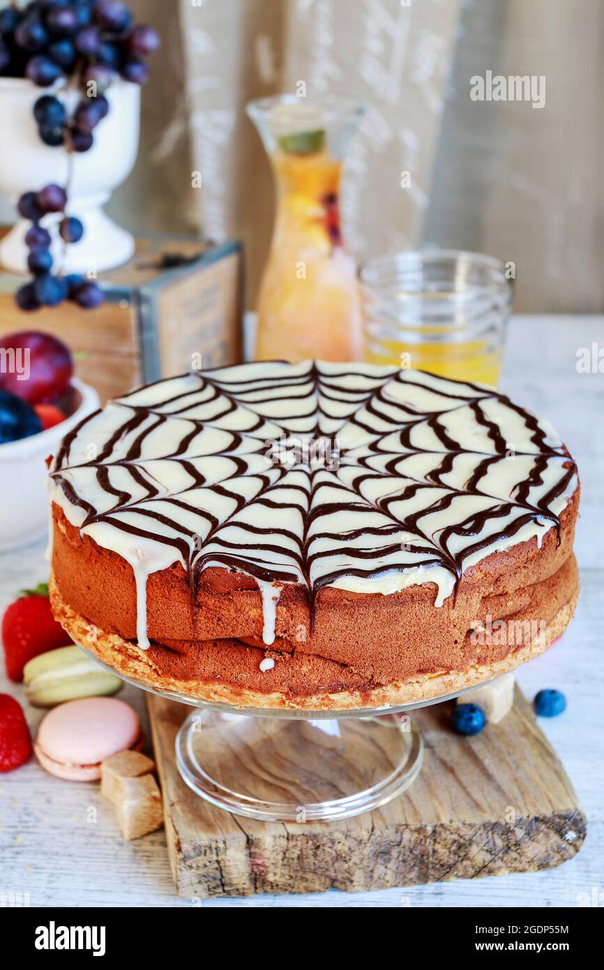 Halloween chocolate spider web cake and various fruits around. Party ...