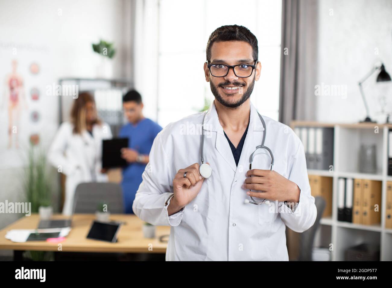 Handsome likable young male Malay Arab medical doctor is looking at ...