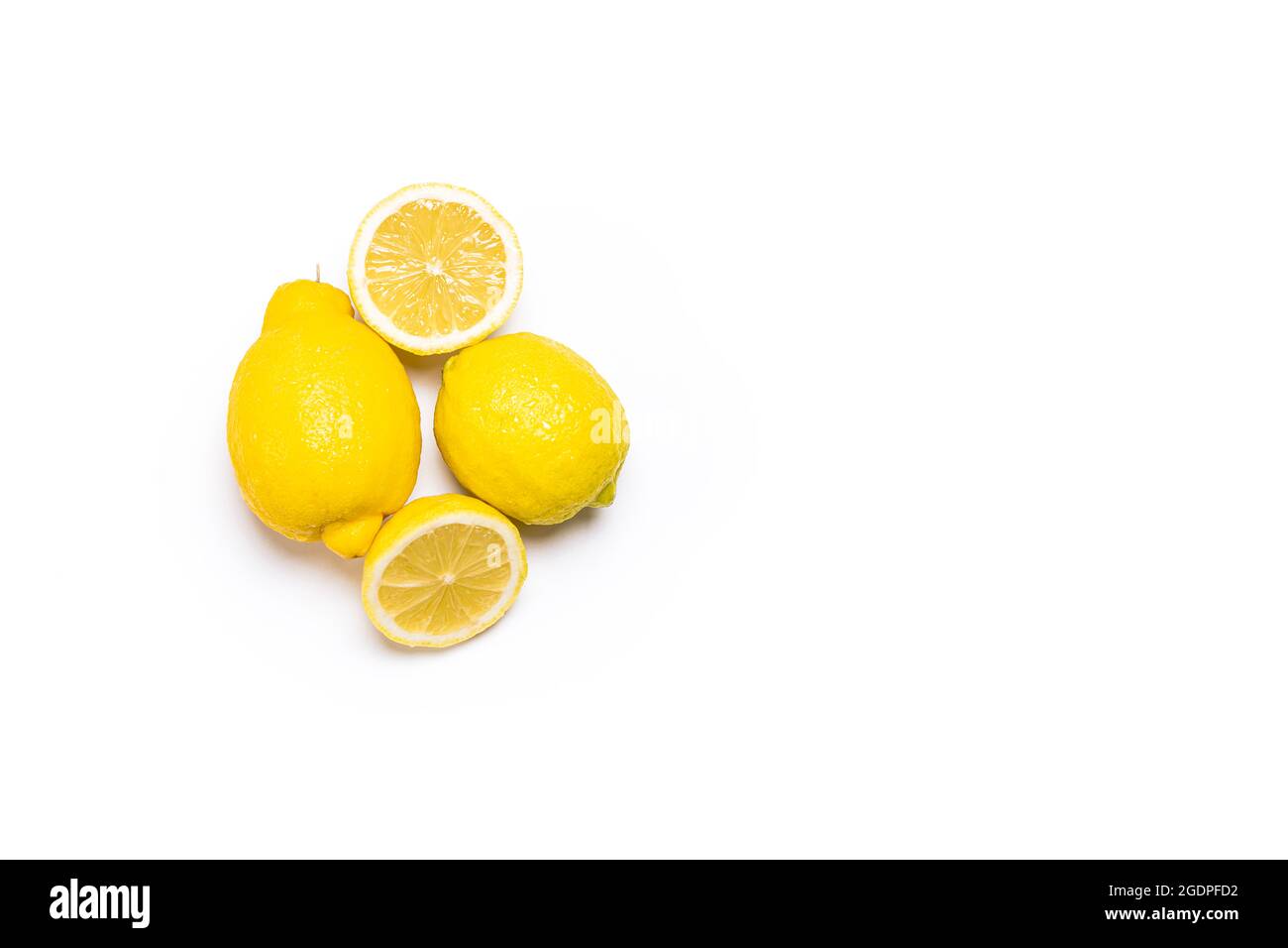 Overhead photograph of two lemons and a lemon in two halves on a white ...