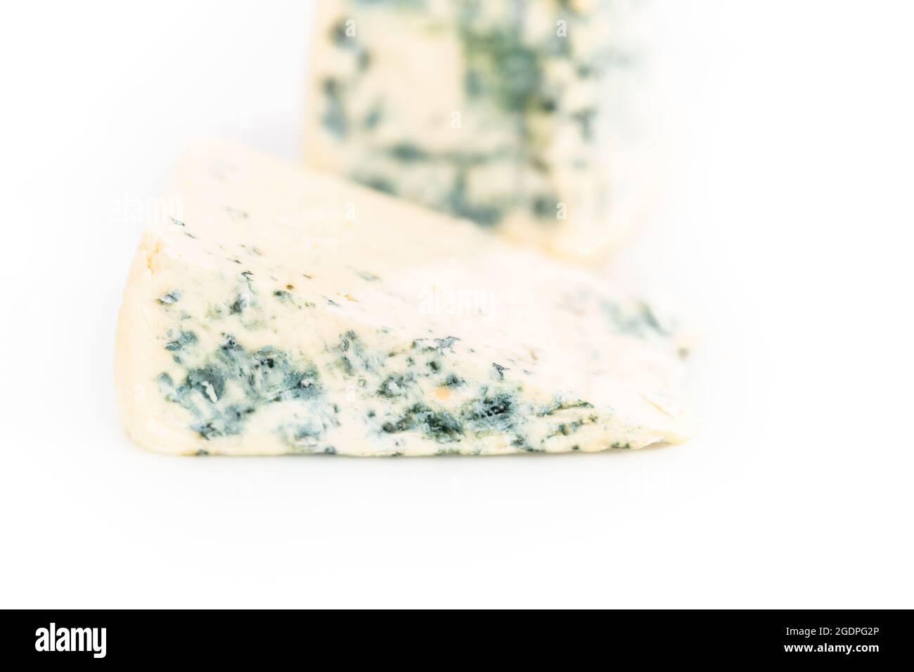 Large slice of blue cheese on a white background Stock Photo - Alamy