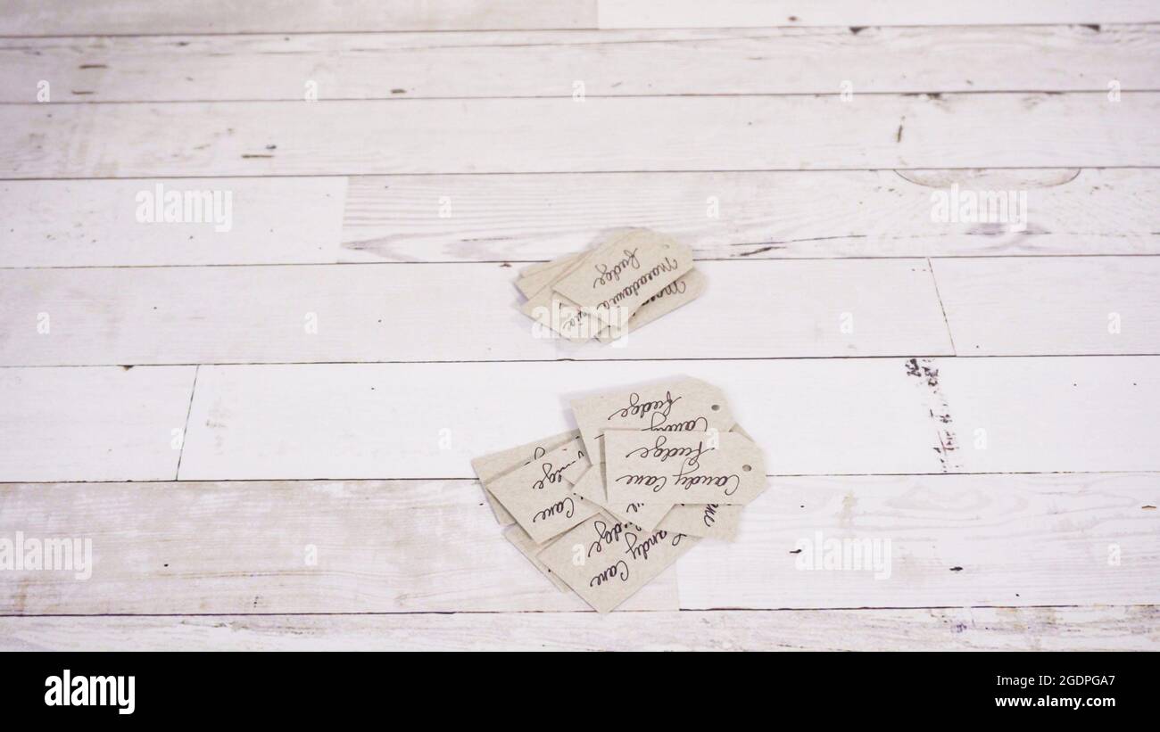 Step by step. Labeling brown paper gift tags with a black marker Stock ...
