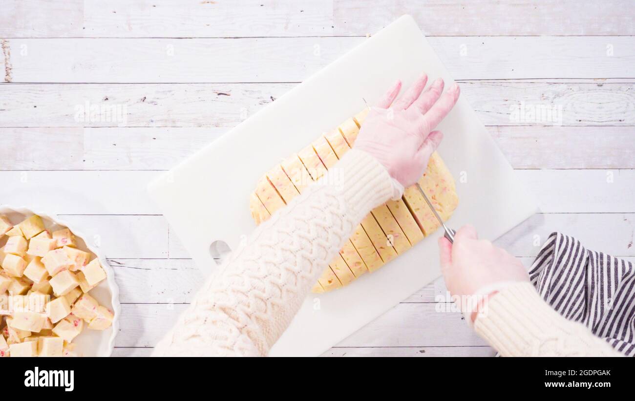 Flat lay. Step by step. Cutting homemade candy cane fudge on a white ...