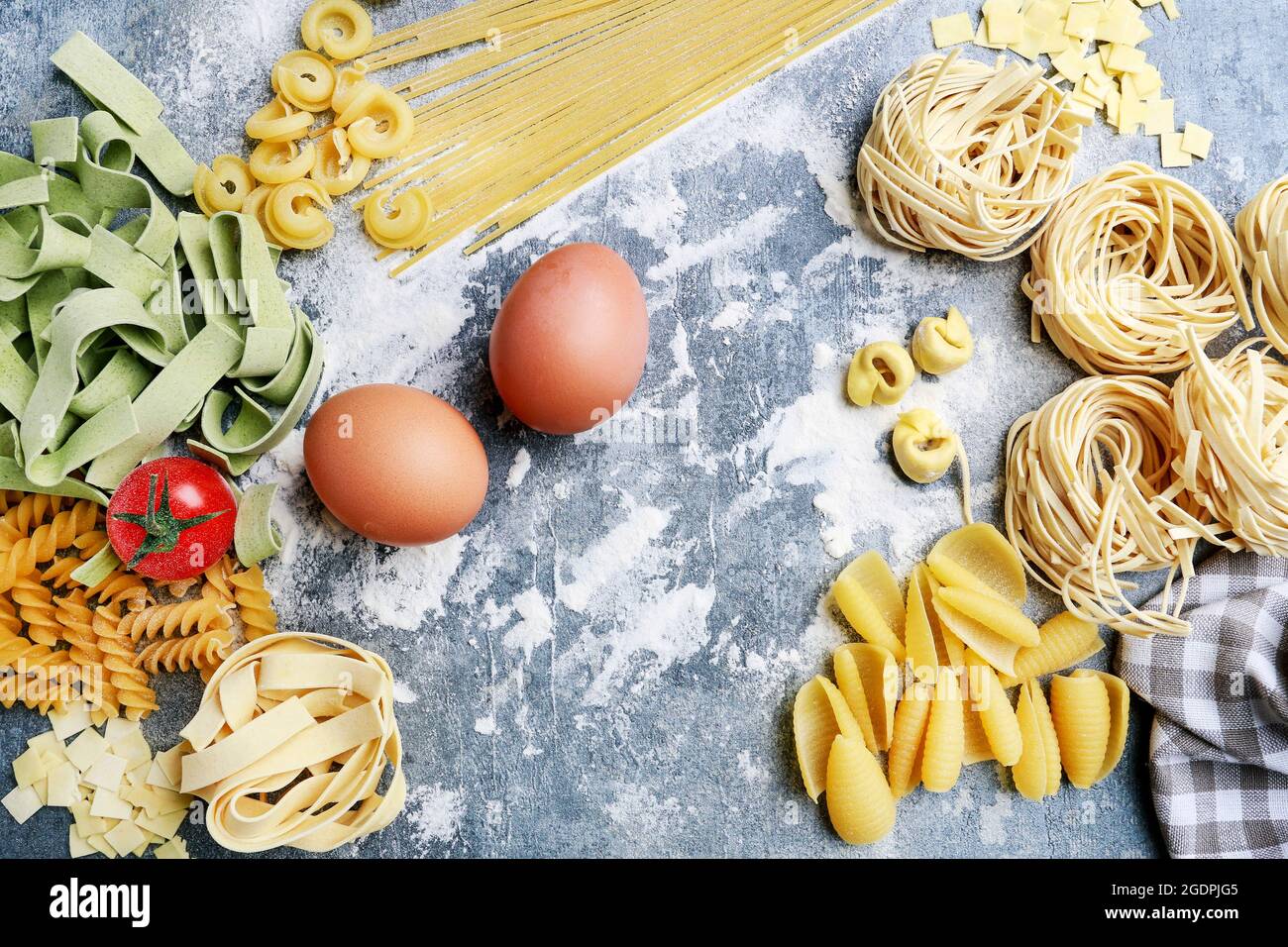Mixed types and shapes of italian pasta on grey stone, background. Copy ...