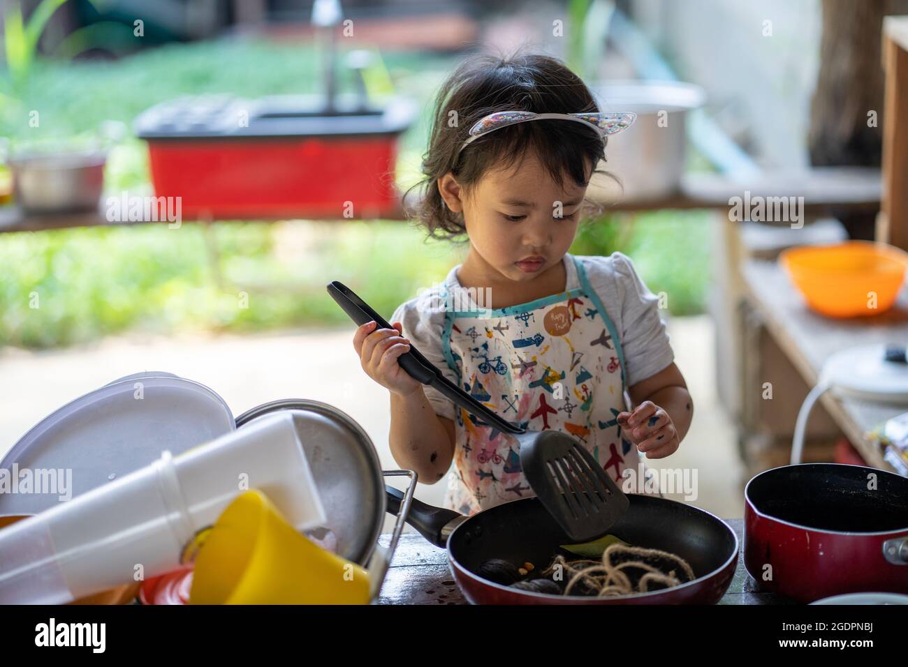 Little Thai girl cooking in the kitchen Stock Photo - Alamy