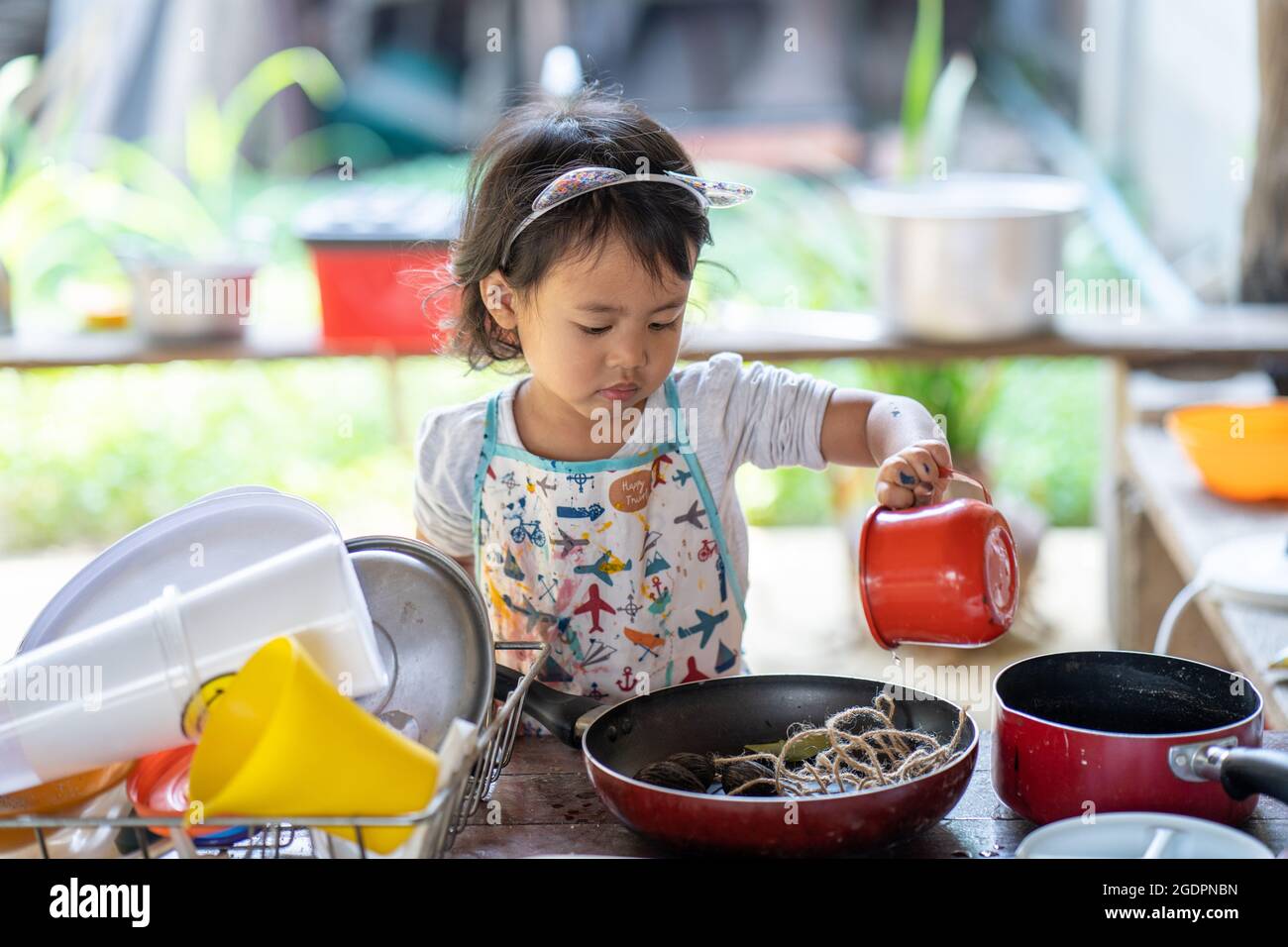 Little Thai girl cooking in the kitchen Stock Photo - Alamy