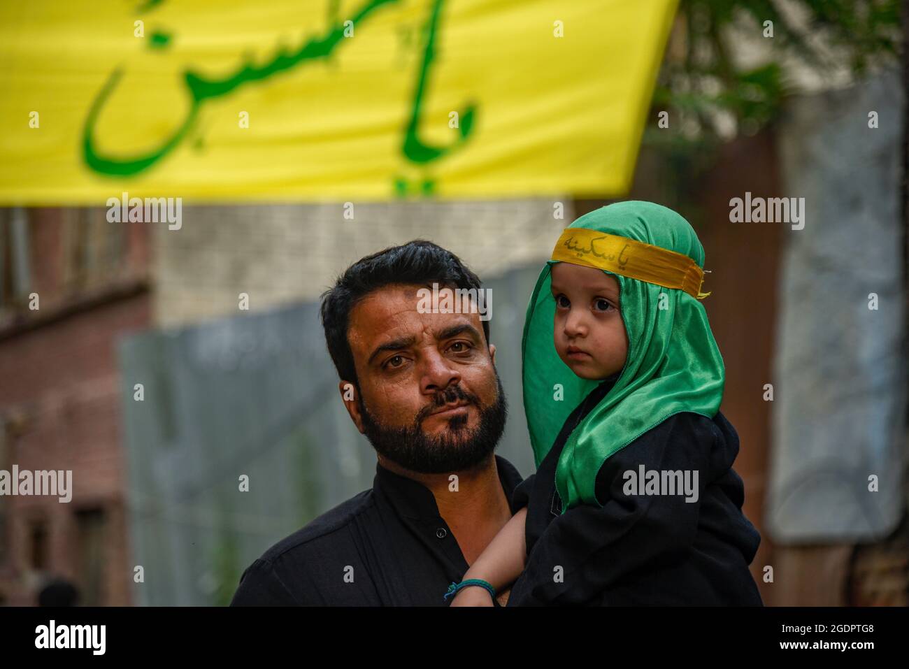 A Kashmiri Shia man carries a kid during a muharram procession in ...
