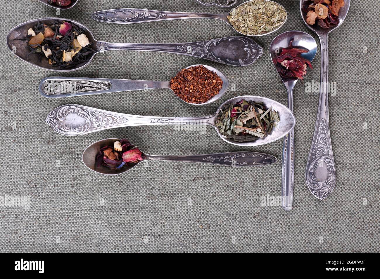 Tea in metal spoons on grey fabric background Stock Photo - Alamy