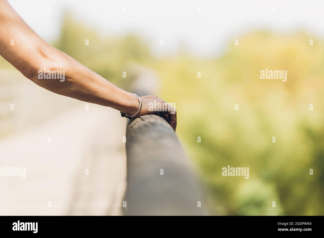 Arm of a woman with a bracelet leaning on a wooden railing Stock Photo ...