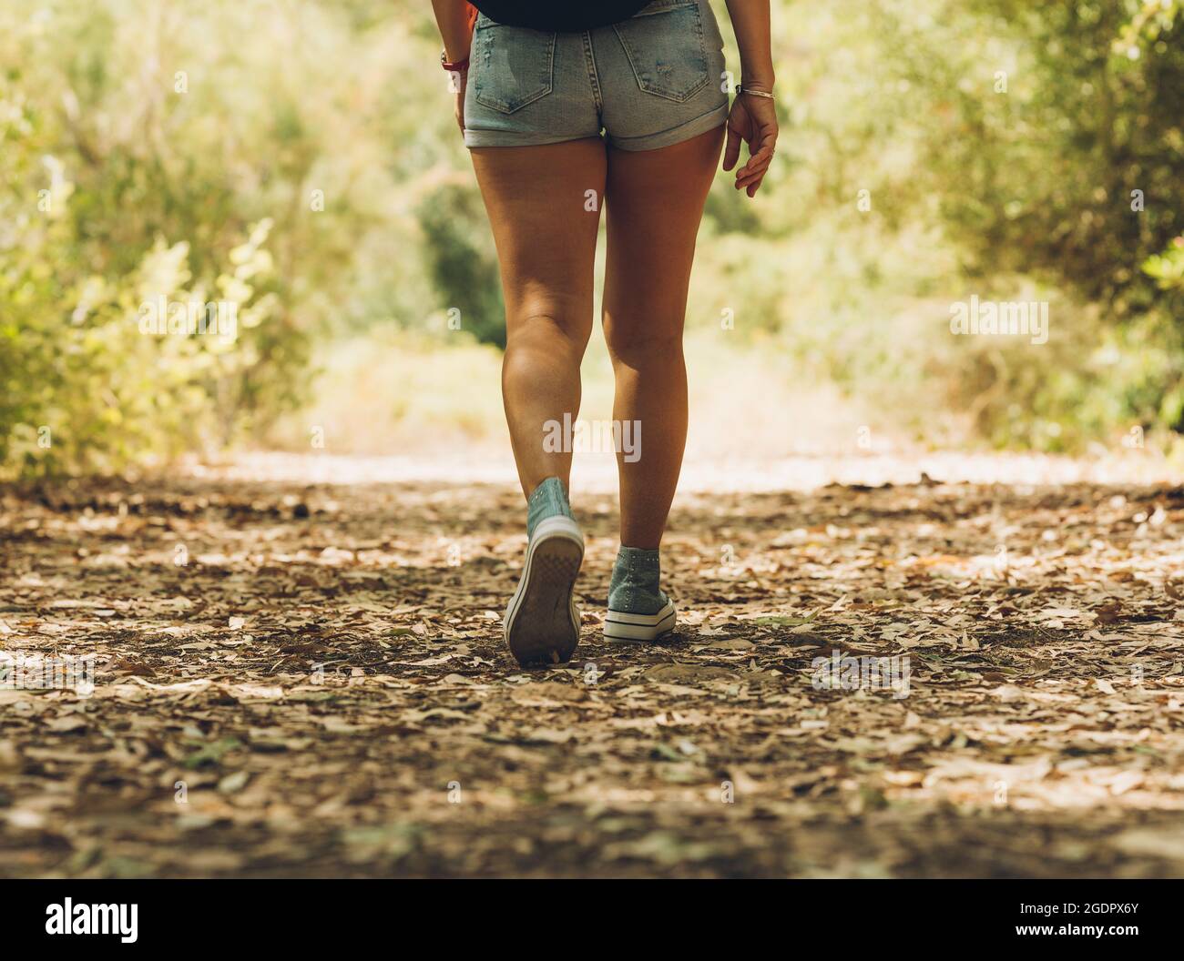 Legs of a woman in shorts walking across a the forest Stock Photo - Alamy