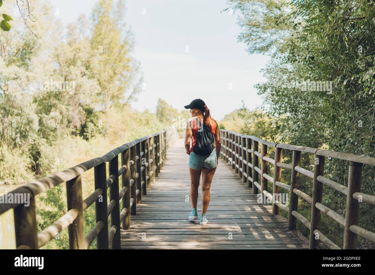 Woman walking across a bridge on a rural footpath Stock Photo - Alamy