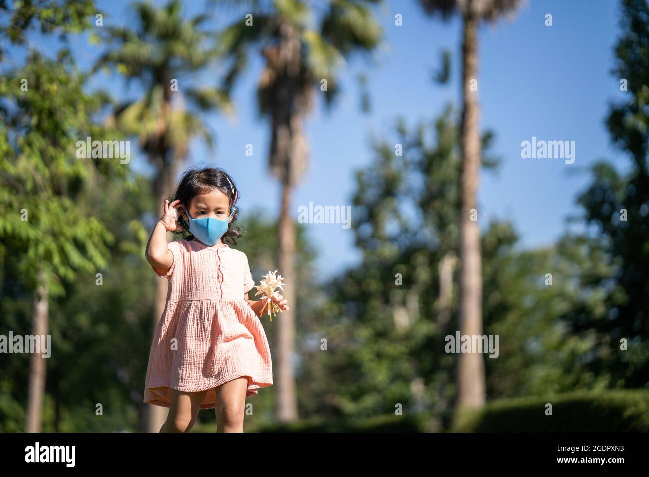 Cute Southeast Asian female child walking outdoor wearing a healthy ...