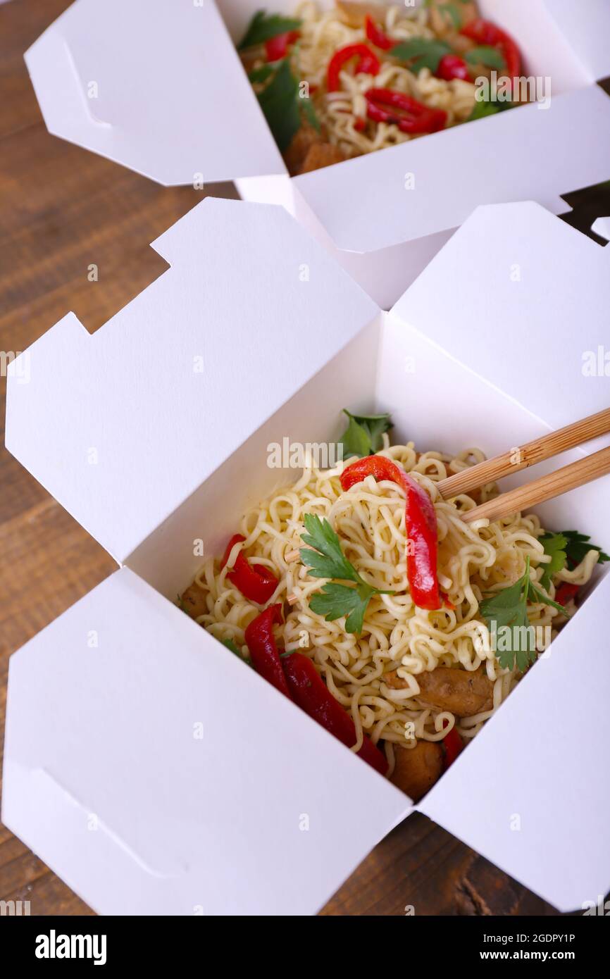 Chinese noodles and sticks in takeaway boxes closeup Stock Photo - Alamy