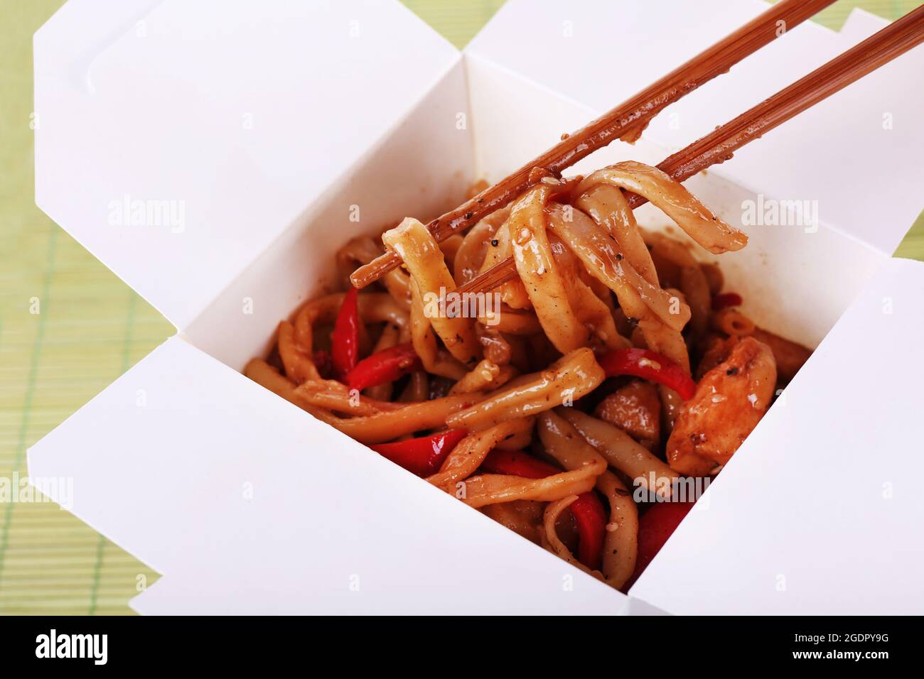 Fried noodles in takeaway box on mat background Stock Photo - Alamy