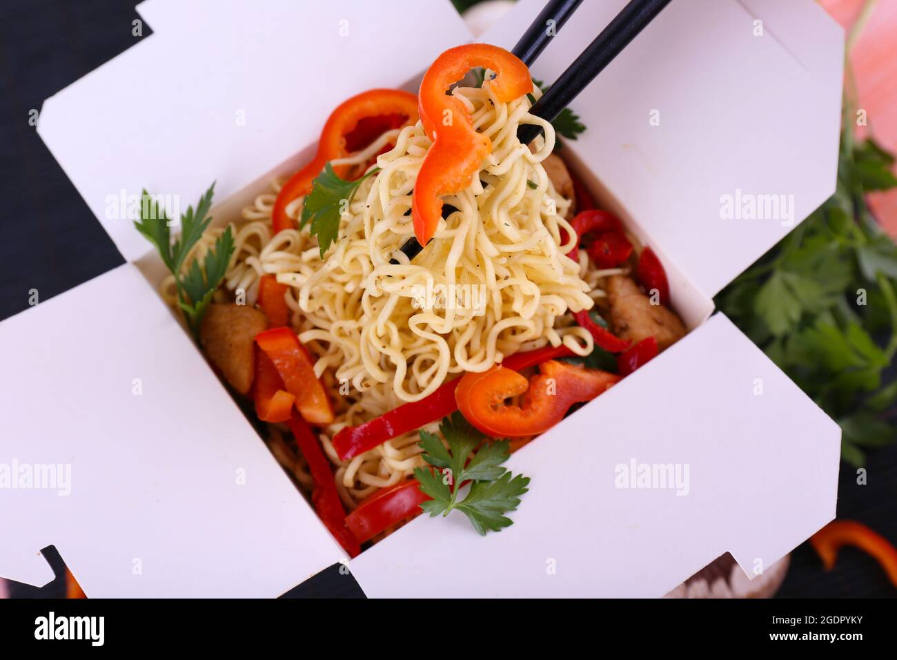Chinese noodles in takeaway box on black mat background Stock Photo - Alamy