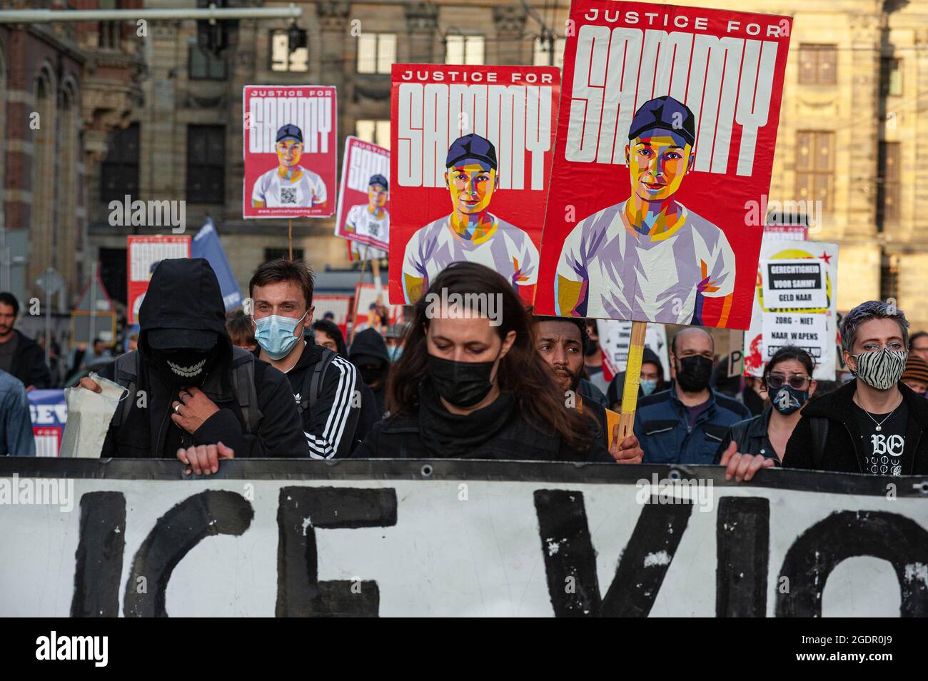Protesters hold a banner and placards while marching on the streets of ...