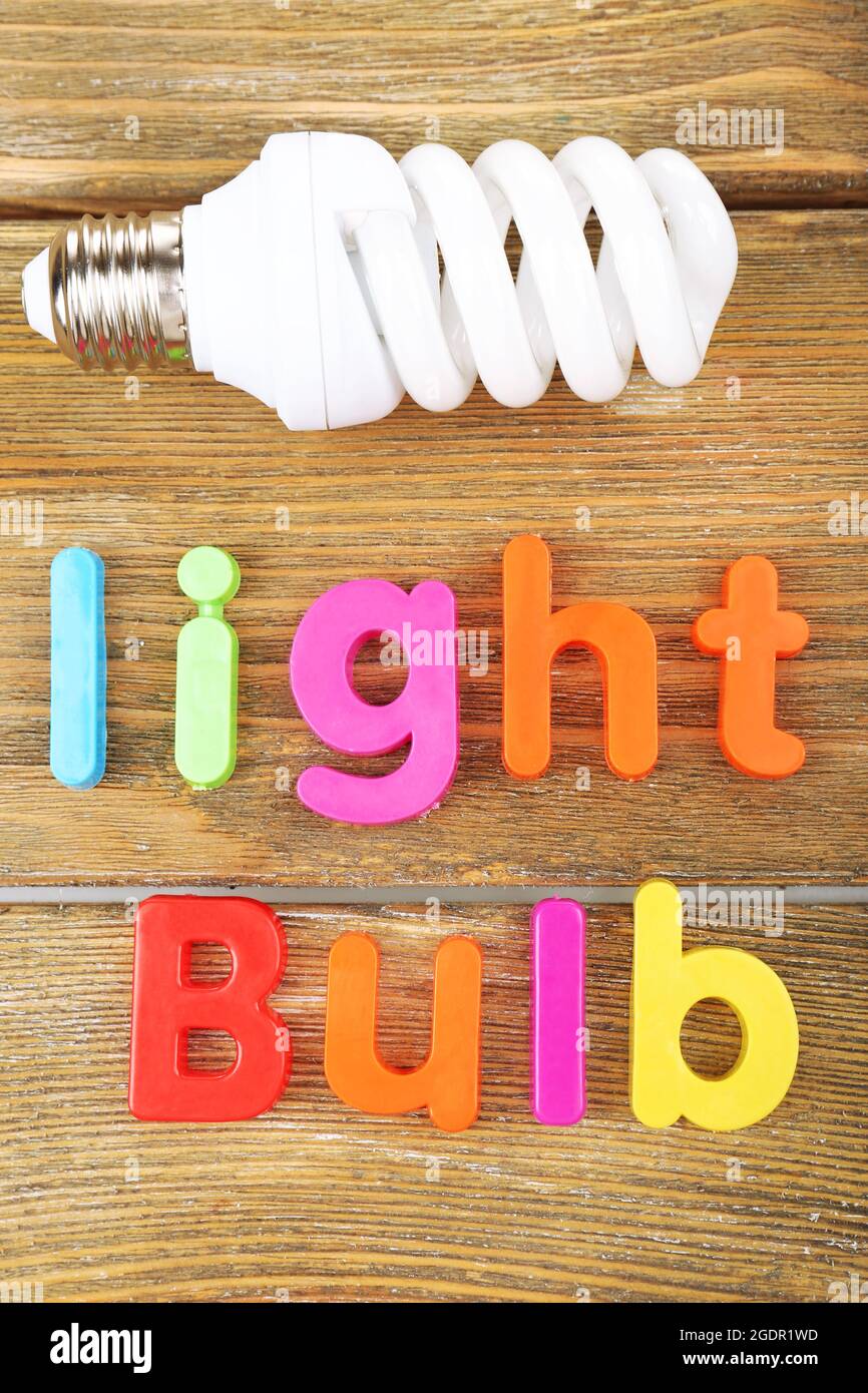 Light bulb word formed with colorful letters on wooden background Stock ...