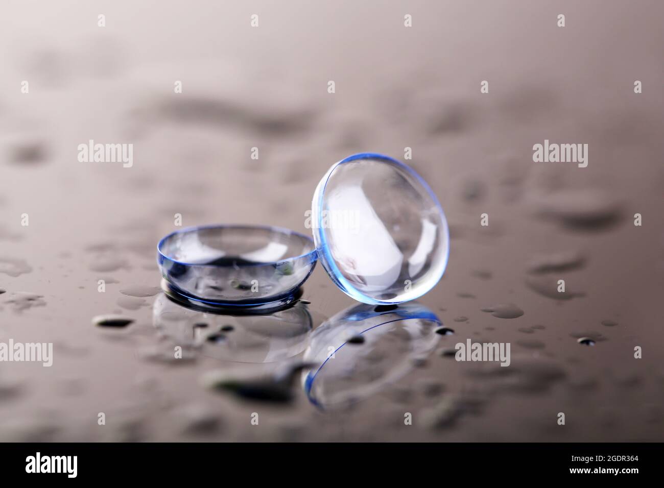 Contact lenses with water drops on bright background Stock Photo - Alamy