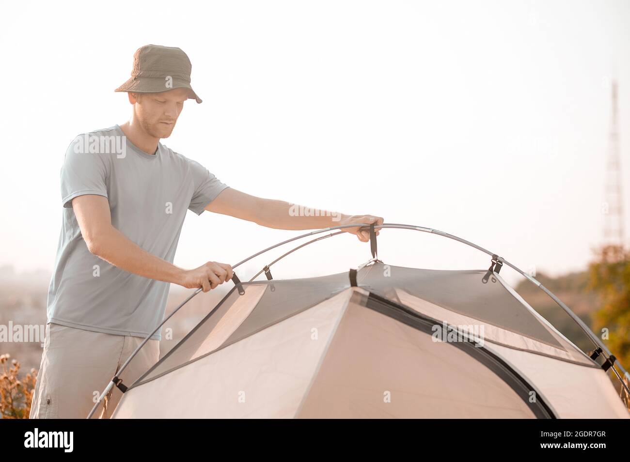 Pitching the tent. A picture of a young man looking busy with pitching ...