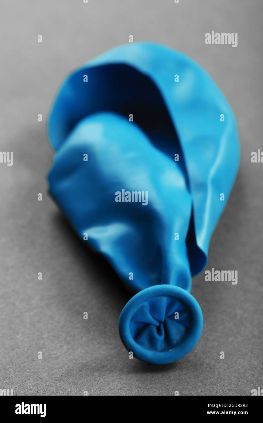 Popped blue balloon on paper background Stock Photo - Alamy