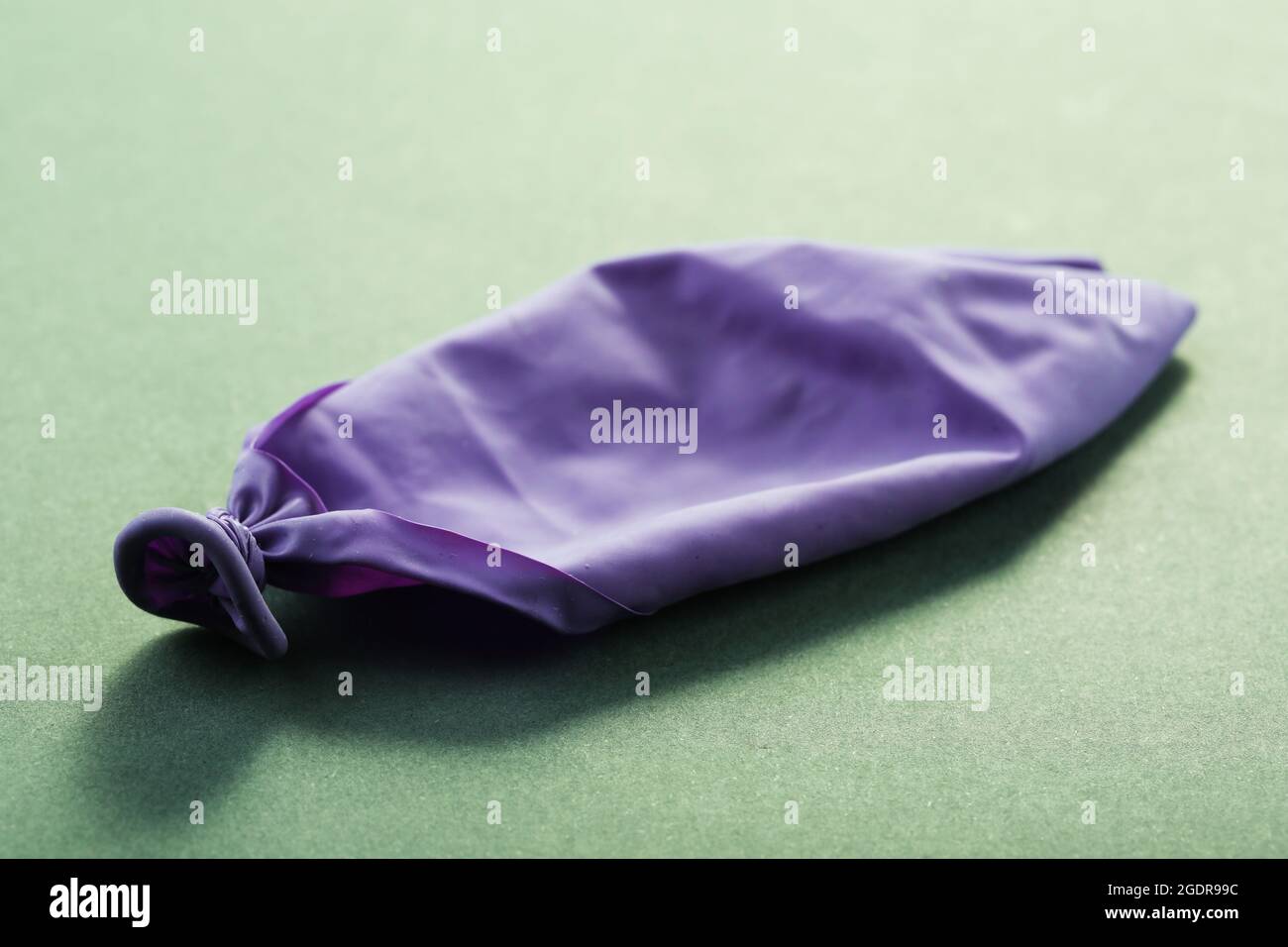 Popped violet balloon on paper background Stock Photo - Alamy