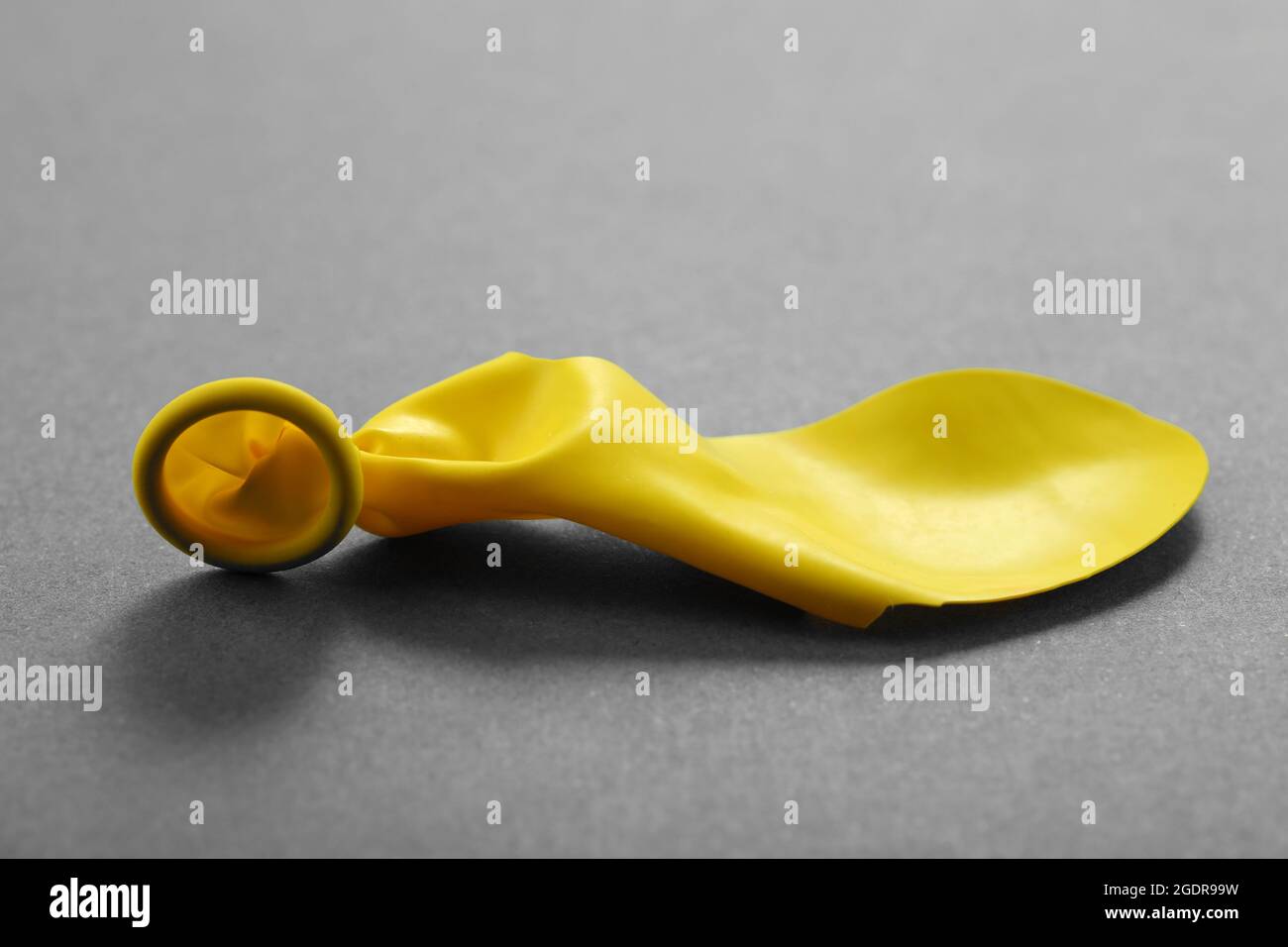 Popped yellow balloon on paper background Stock Photo - Alamy