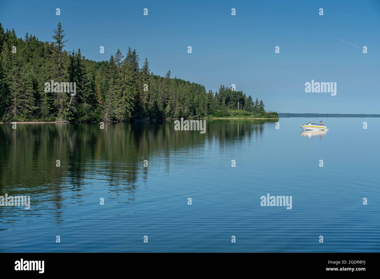 The shoreline of Clear Lake with reflections in Riding Mountain ...