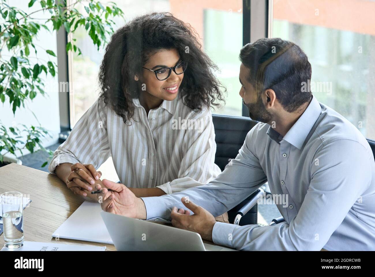 Female smiling trainee listening to indian ceo mentor leader at office ...