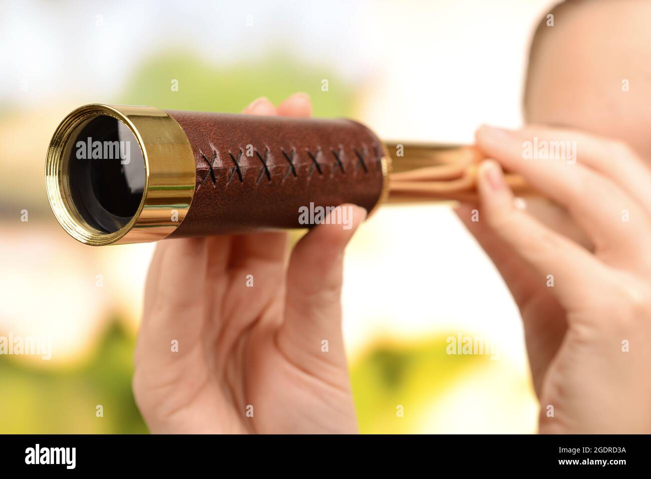 Modern spyglass in hands on bright background Stock Photo - Alamy