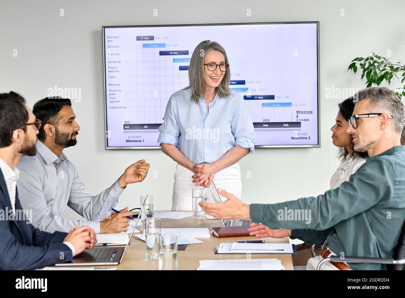 Happy diverse corporate team having presentation in boardroom office ...