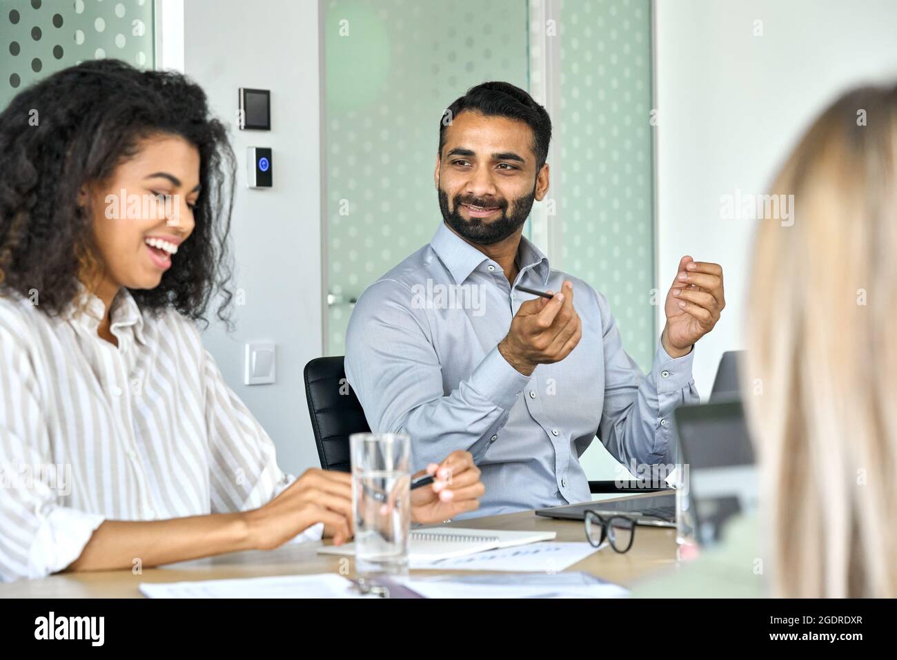 Smiling Afro American and indian managers discussing project at office ...