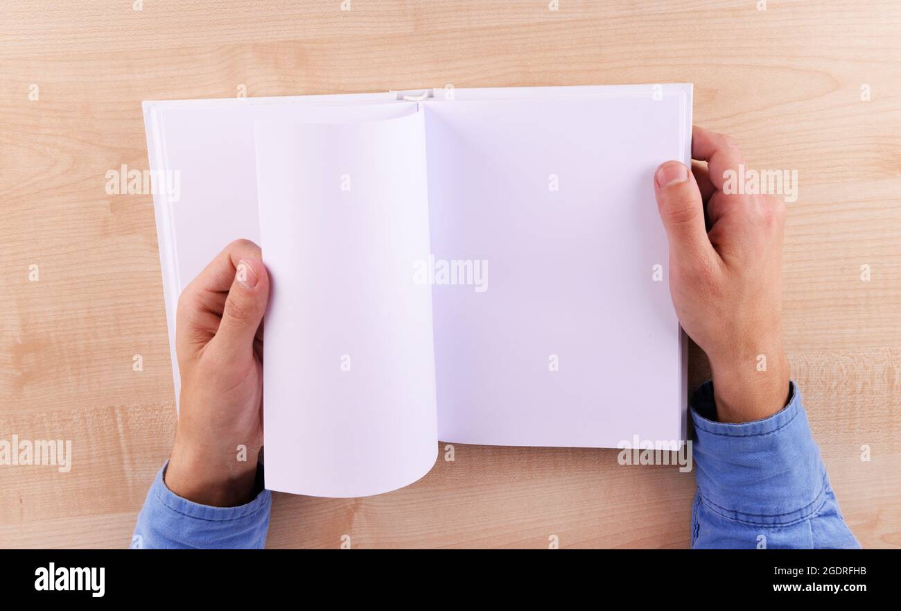 Men reading empty open book on wooden table background Stock Photo - Alamy