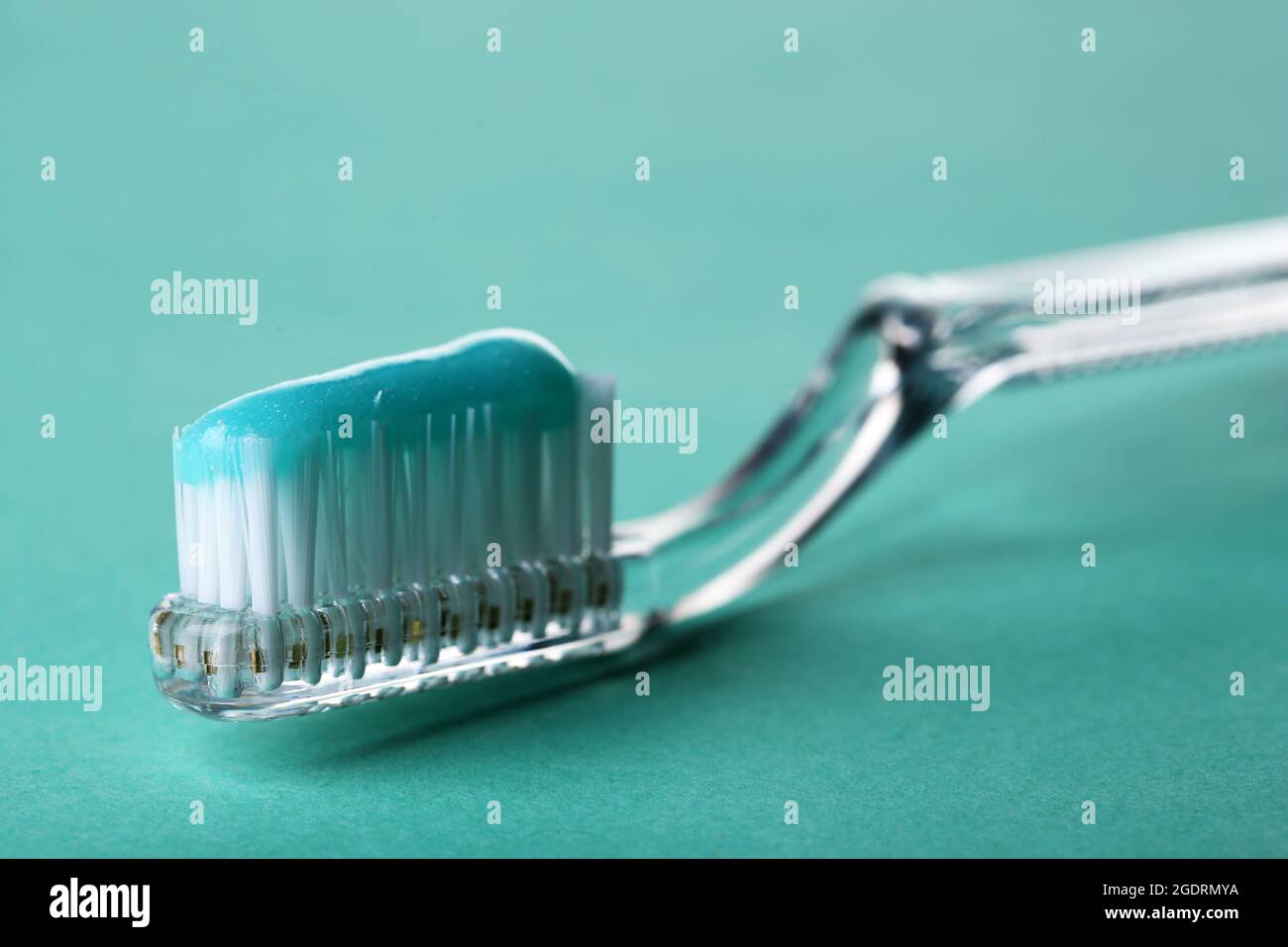 Toothbrush with blue toothpaste on color background Stock Photo - Alamy