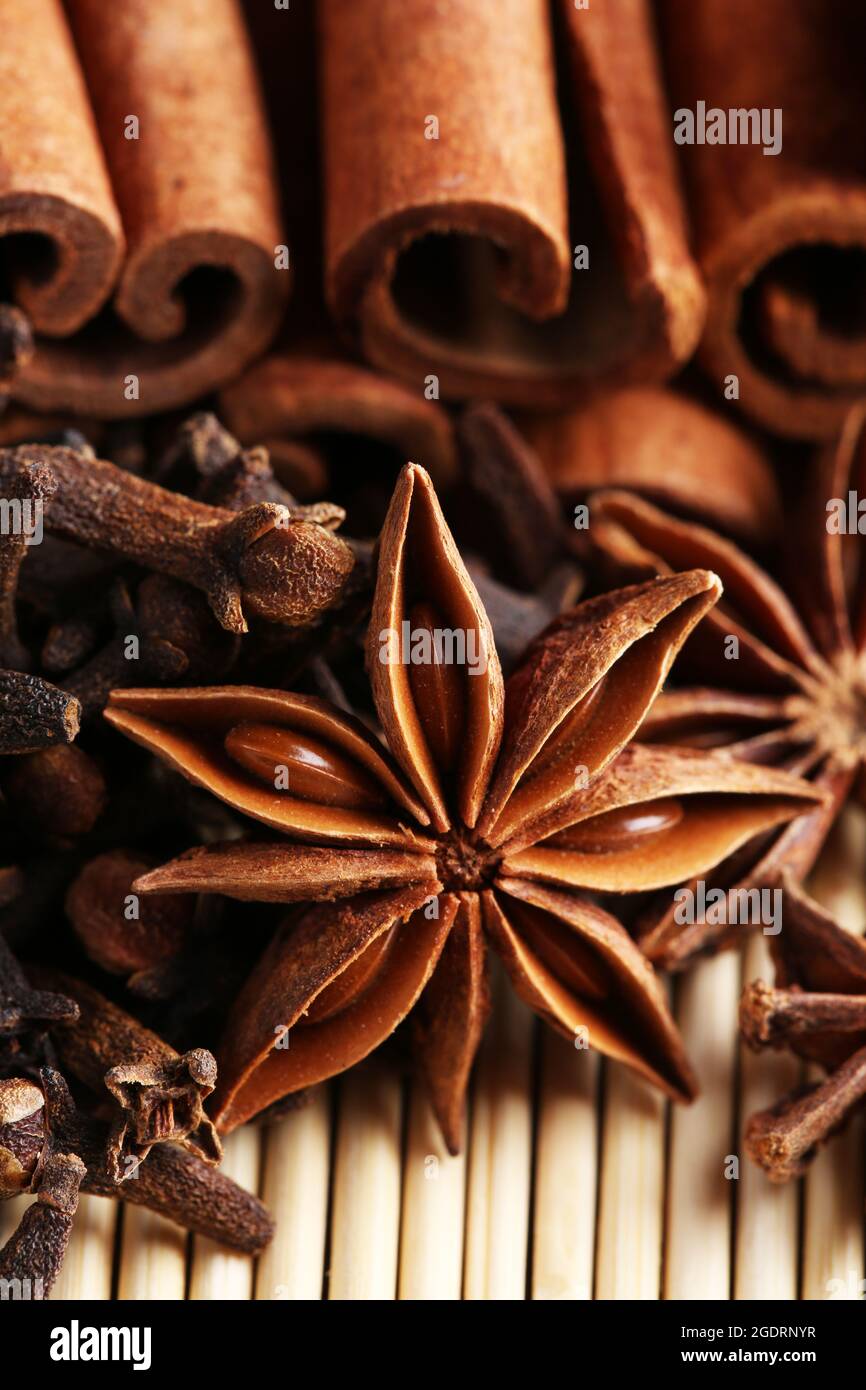 Carnation with cinnamon sticks and star anise on wicker background ...