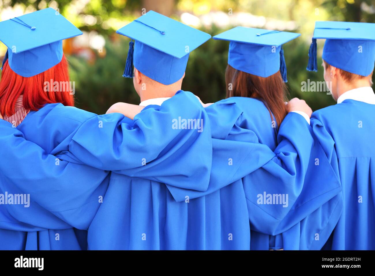 Graduate students wearing graduation hat and gown, outdoors Stock Photo ...