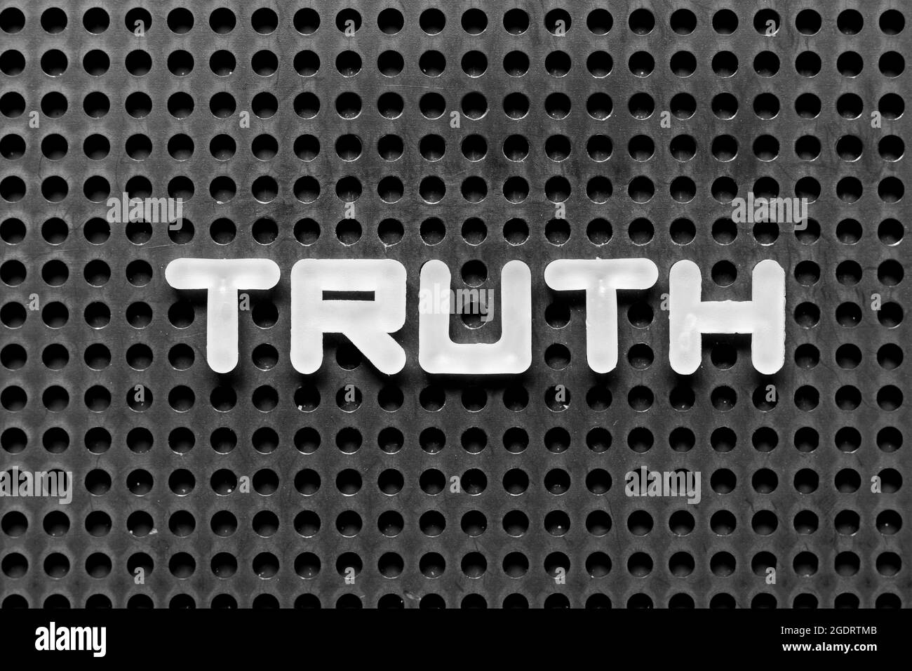 White alphabet letter in word truth on black pegboard background Stock ...